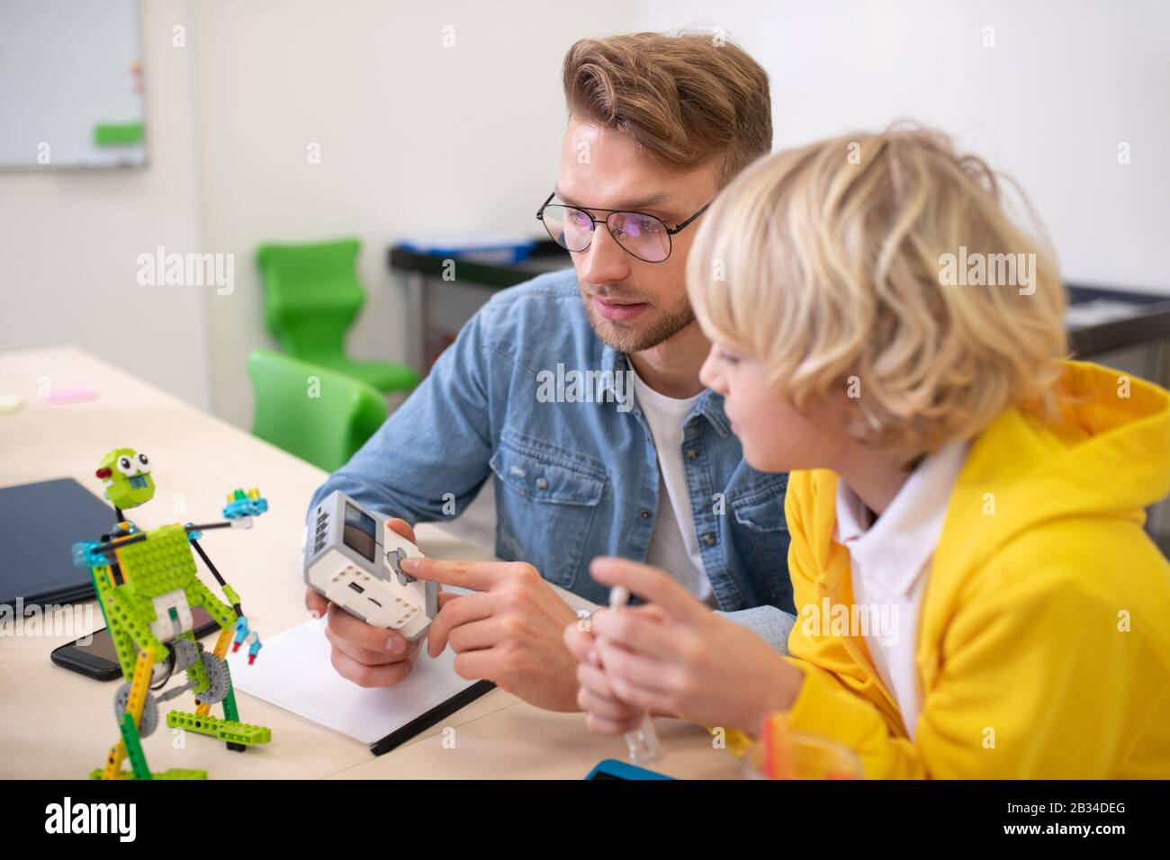 Male teacher pressing buttons on control unit Stock Photo - Alamy