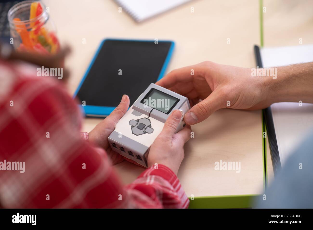 Male teacher hands and girl hands holding control unit Stock Photo - Alamy