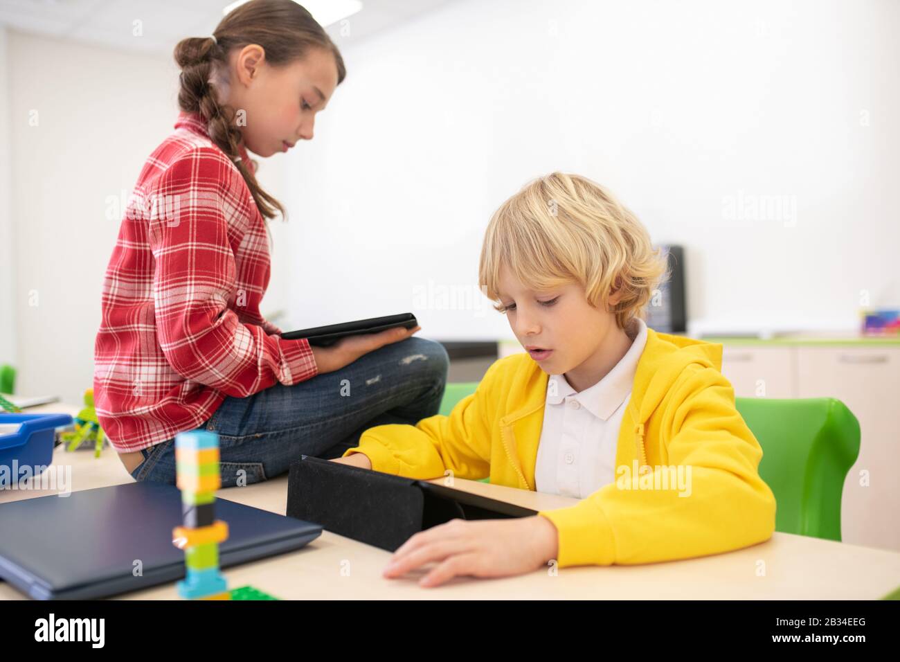 Pupils sitting with tablets, carefully reading something Stock Photo ...