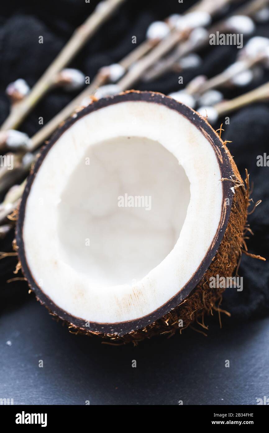 Vertical closeup shot of half a coconut on a grey surface Stock Photo ...