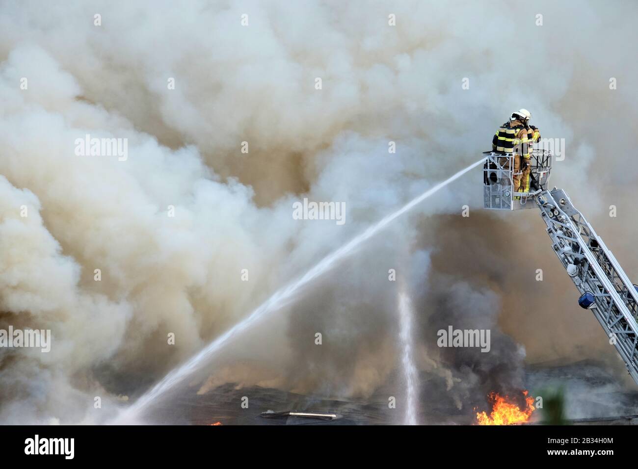 Firefighters trying to stop the fire surrounded by heavy smoke Stock ...