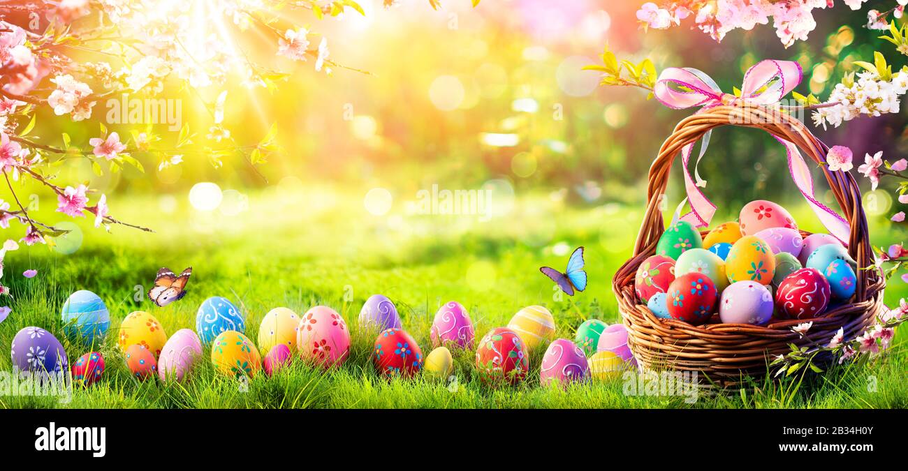 Easter Painted Eggs In Basket On Grass In Sunny Orchard Stock Photo - Alamy