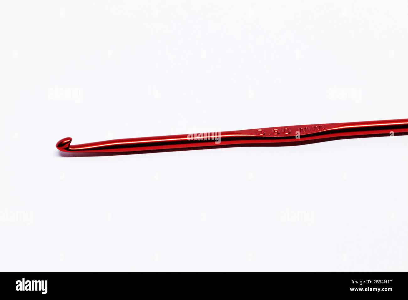 a red crochet hook on white background Stock Photo - Alamy