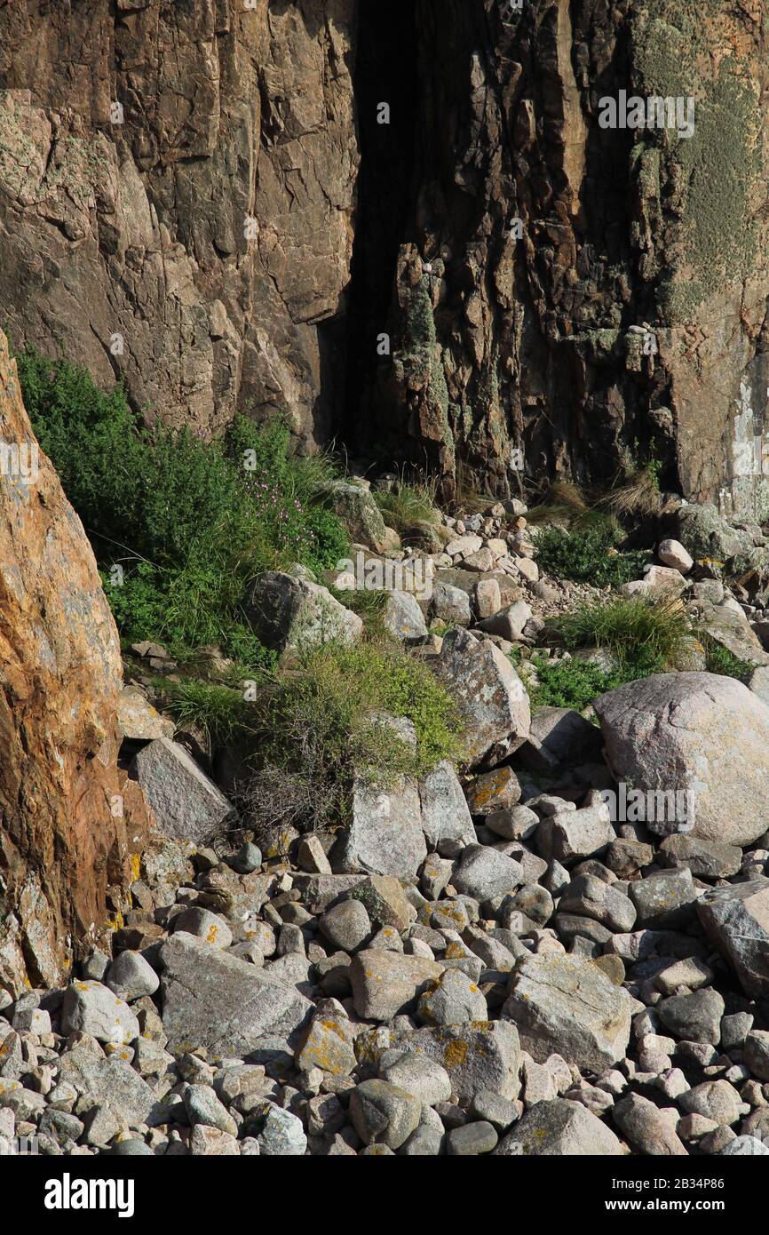 Vertical shot of rocks and boulders at the foot of a cliff in Bornholm ...