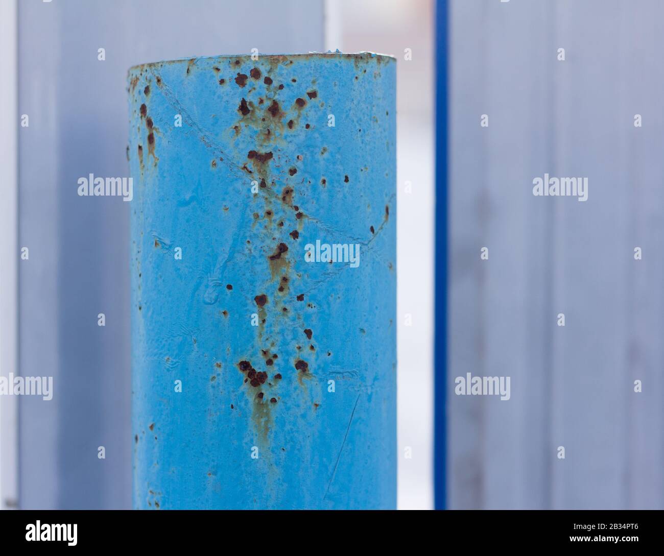 A rusty metal pipe, Rust through the blue paint on an iron post Stock ...