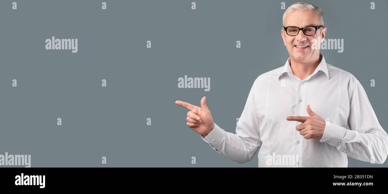 Smiling man pointing fingers at free space Stock Photo - Alamy