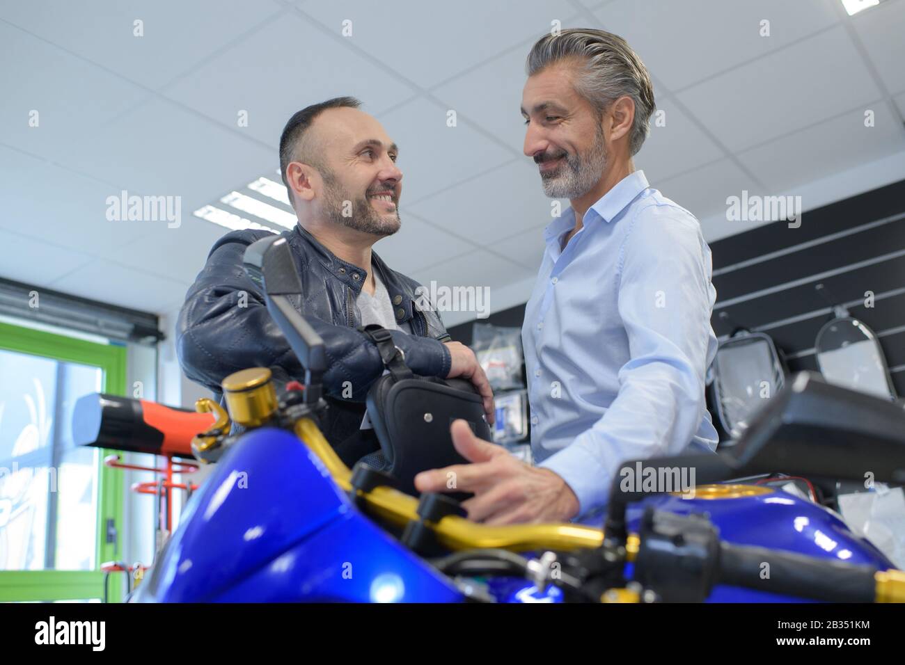 happy man customer holding his motorcycle Stock Photo - Alamy