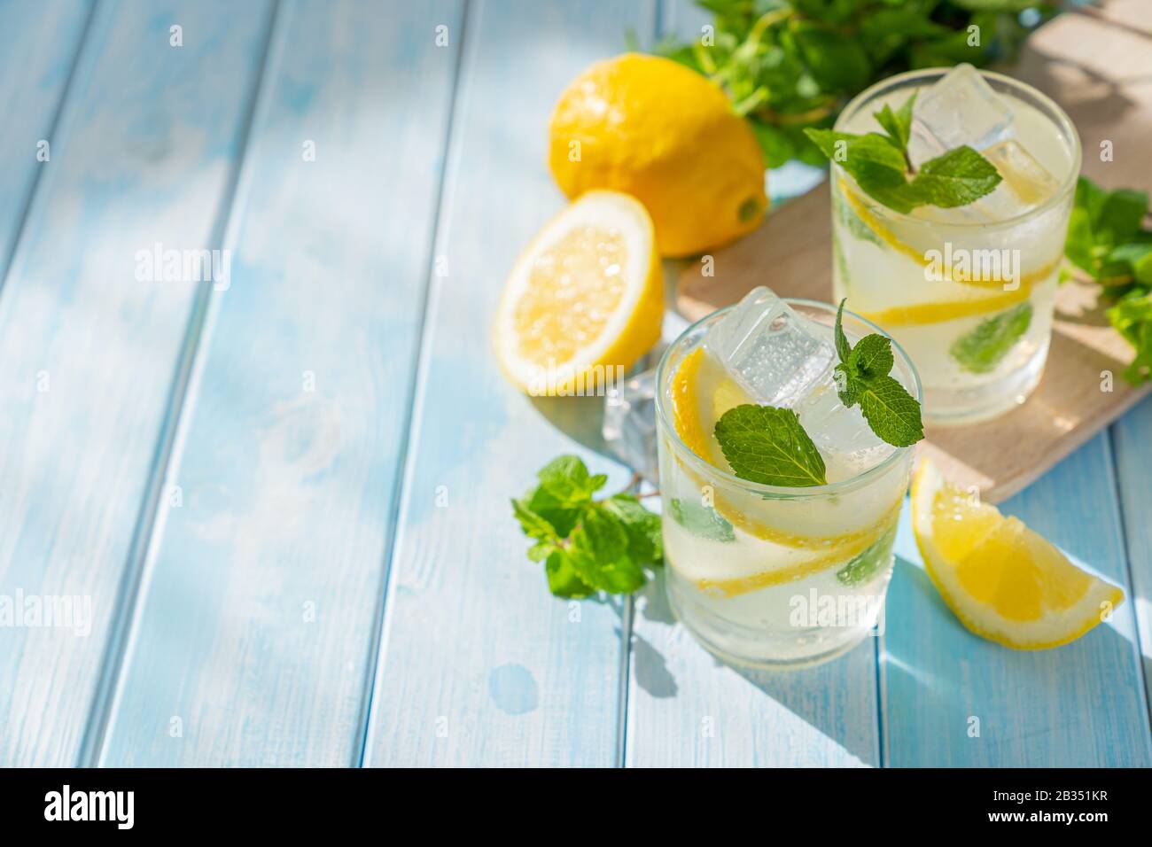 Lemonade and ingredients on blue wood background Stock Photo - Alamy