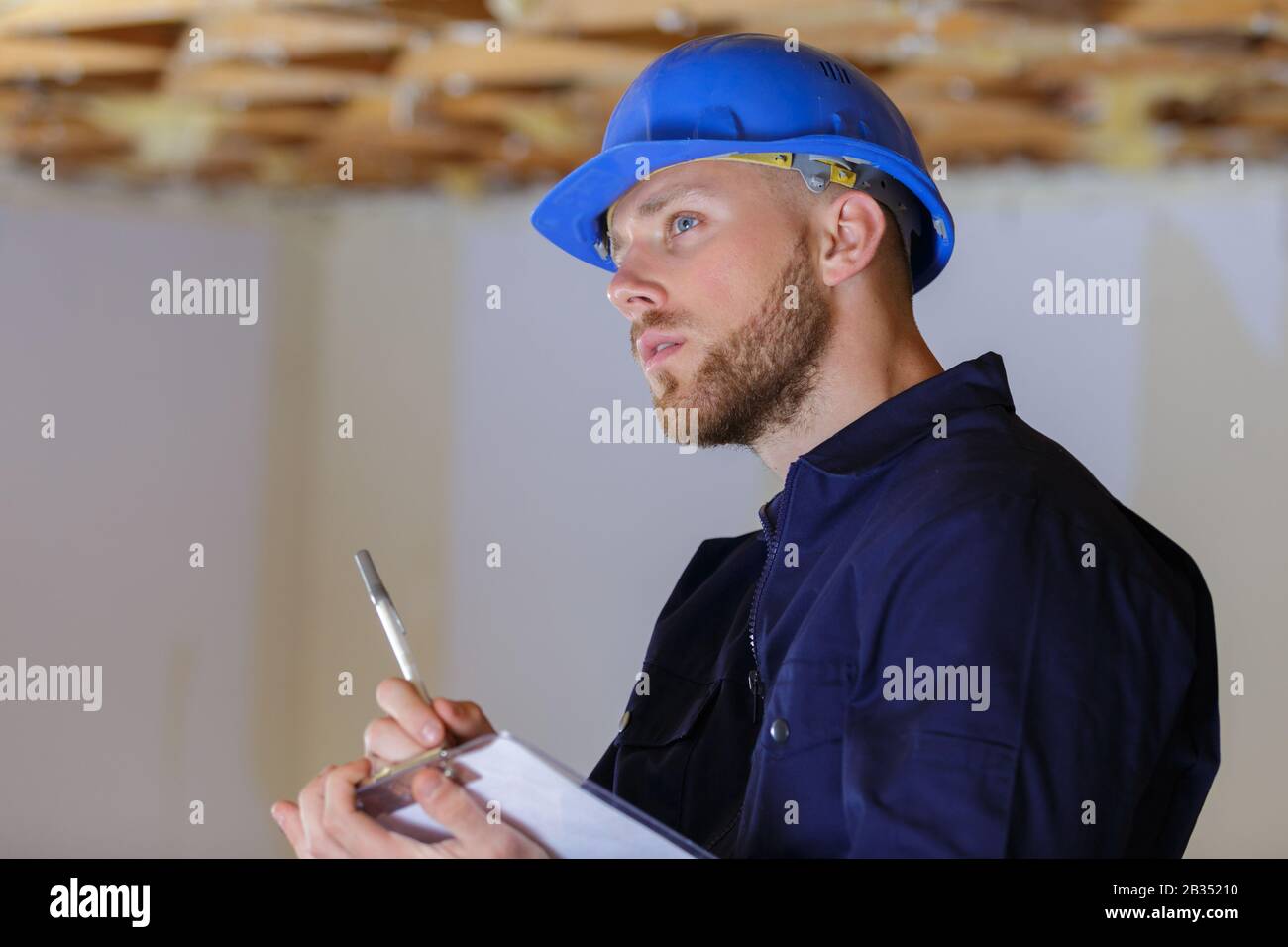 builder holding clipboard stood in property under renovation Stock ...
