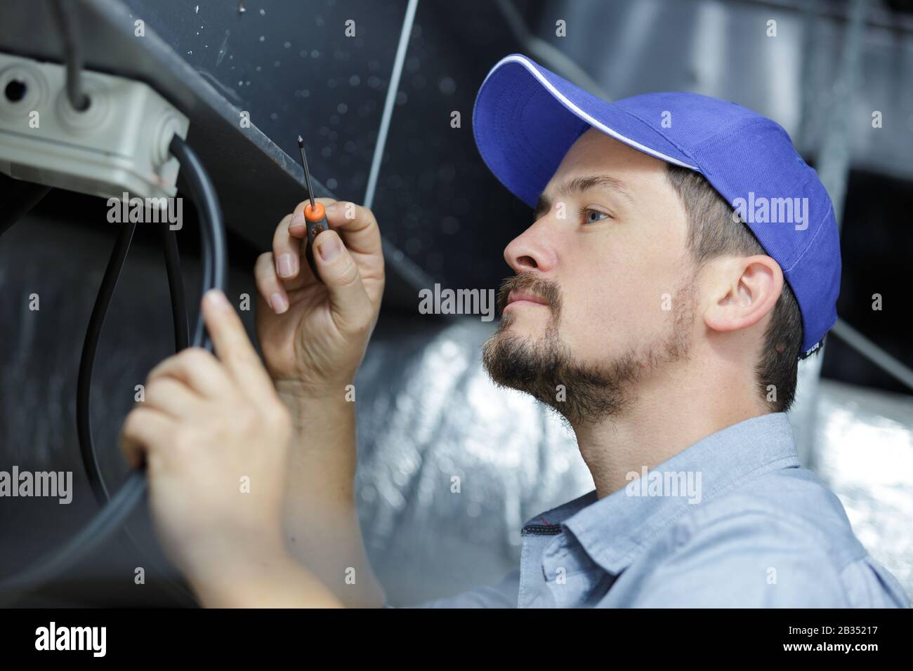 a male worker is fixing cables Stock Photo - Alamy