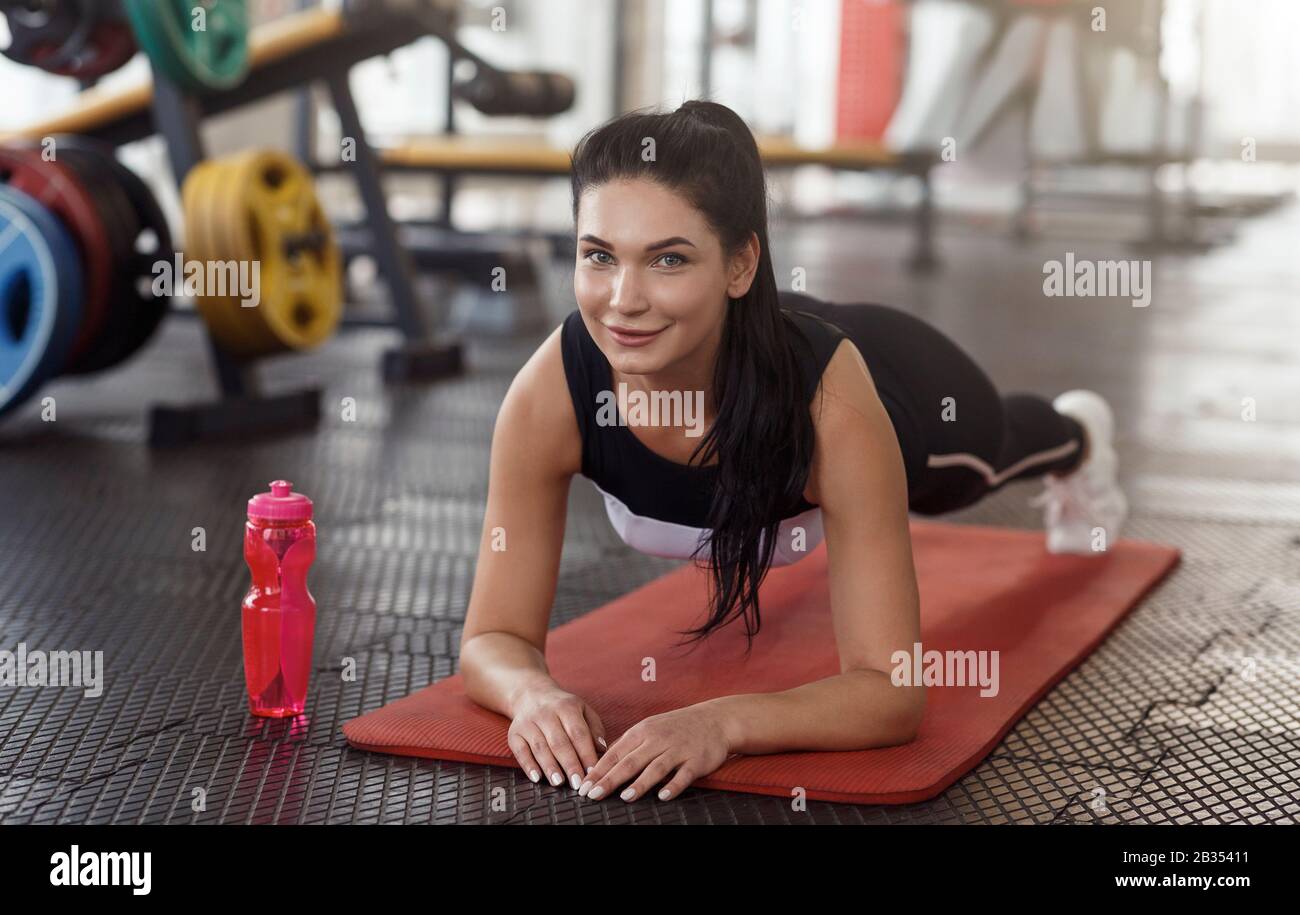 Lovely young lady doing plank exercise in gym Stock Photo - Alamy