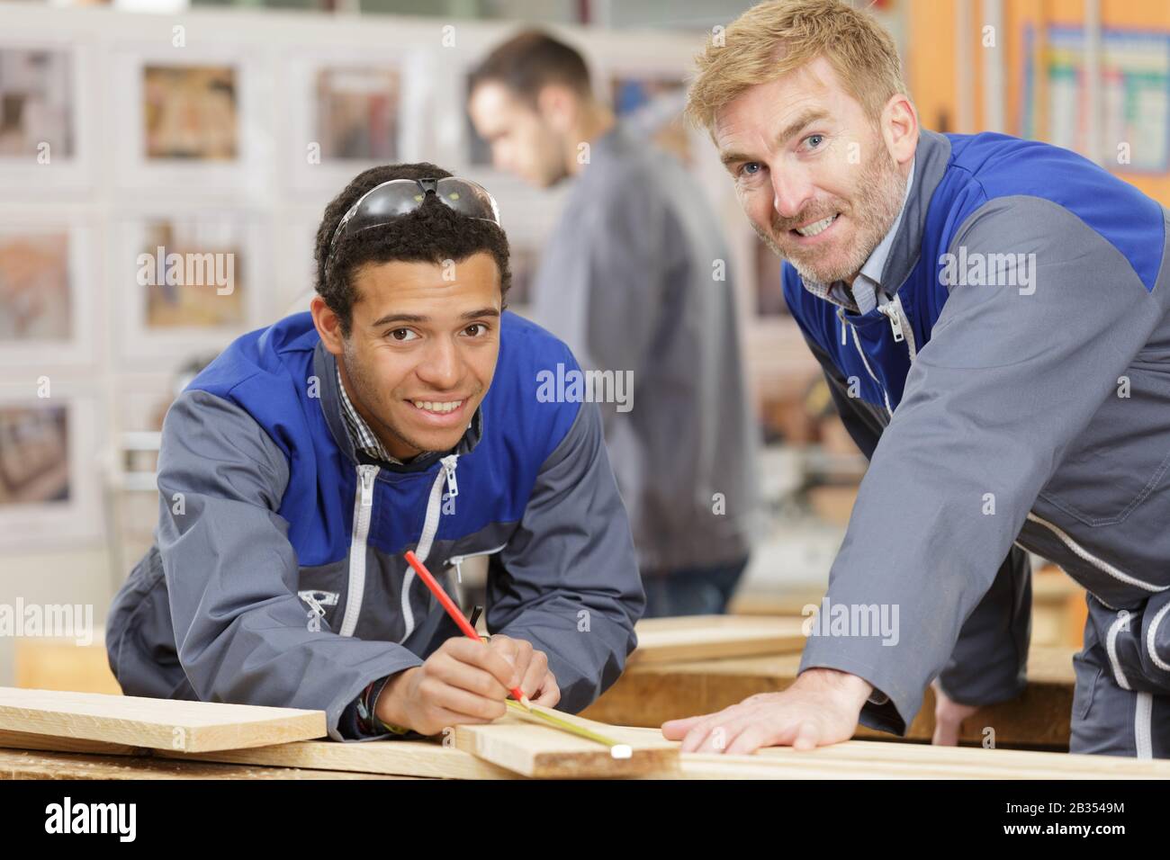 two men measure on the wood Stock Photo - Alamy