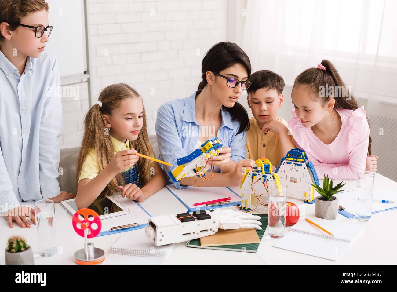 Robotics class. Teacher helping childern making diy robots Stock Photo ...