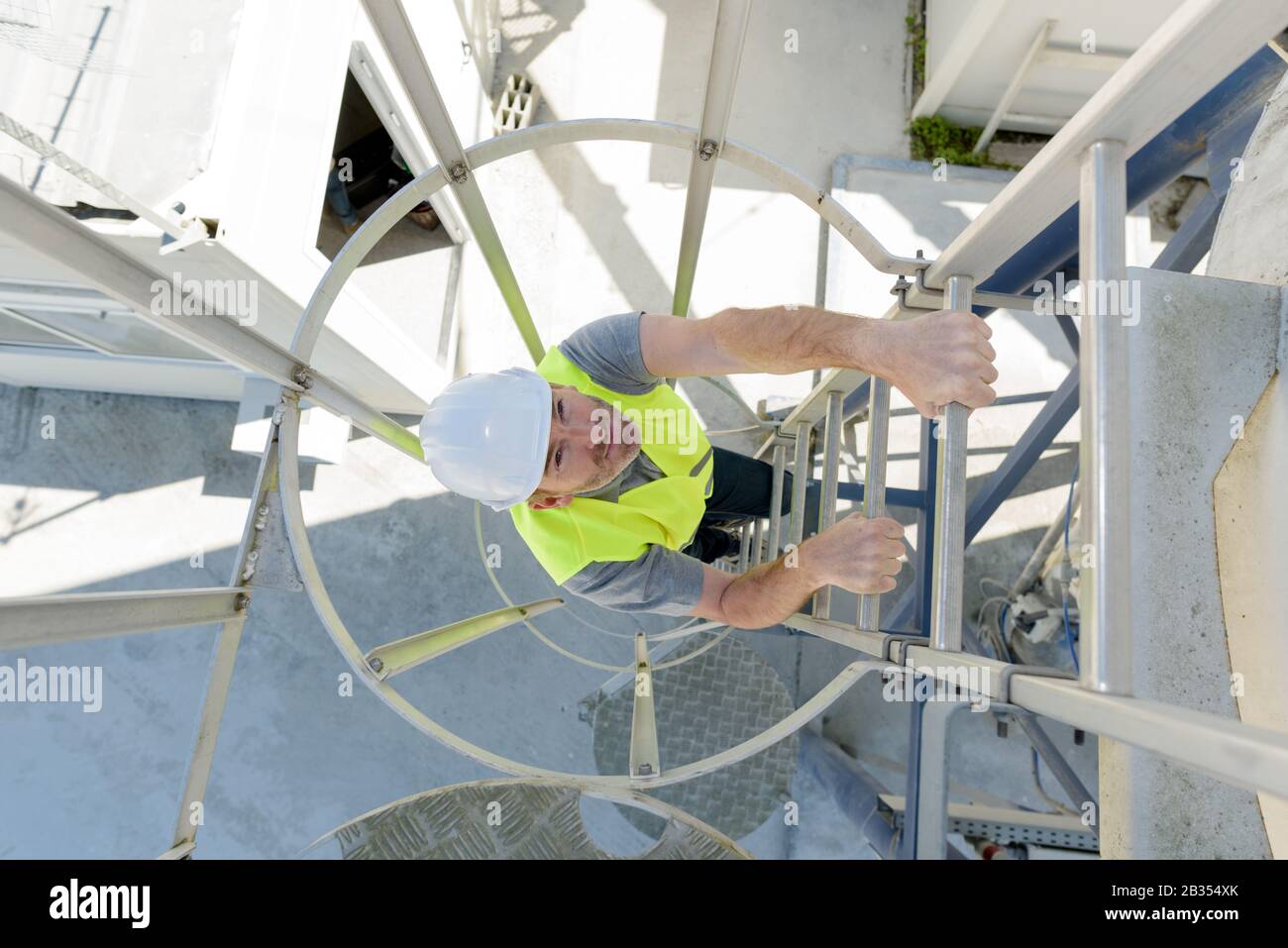man climbing a fixed ladder of a telecommunication tower Stock Photo ...