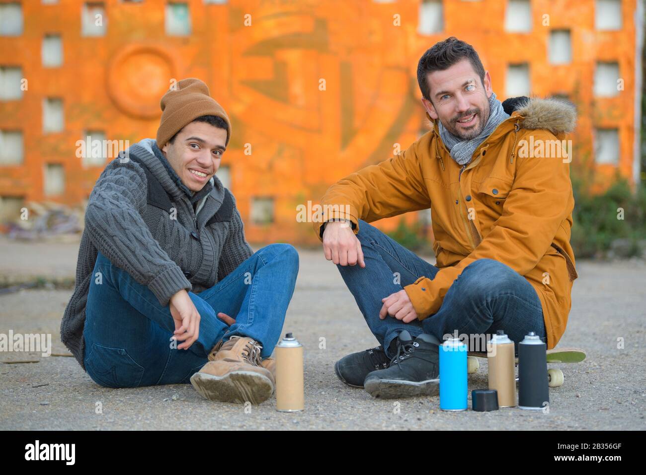 two graffiti artist with color spray cans in hands Stock Photo - Alamy
