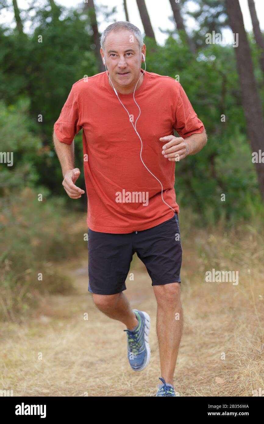 Senior man jogging on grass hi-res stock photography and images - Alamy