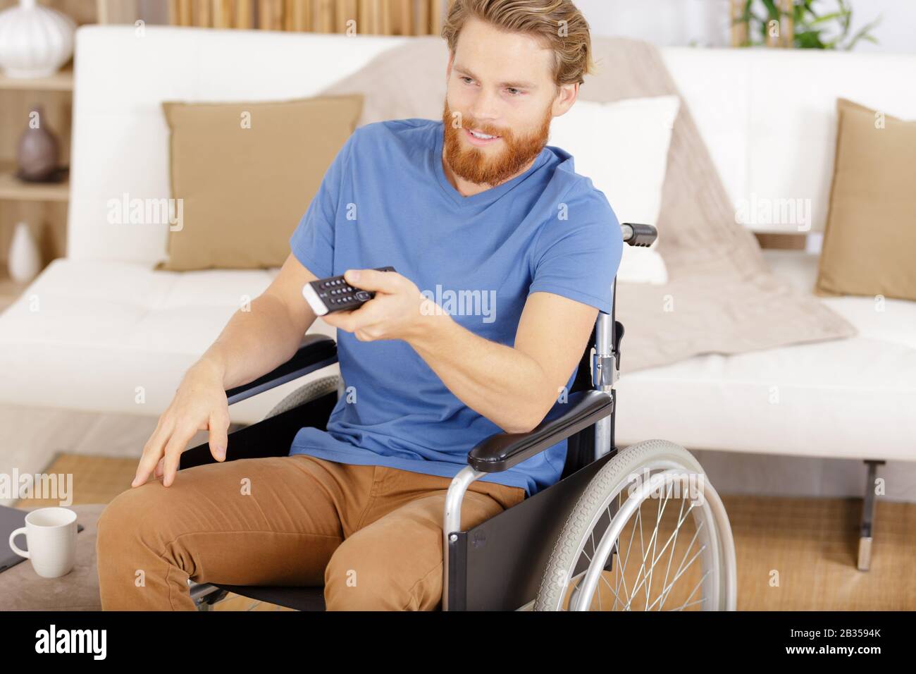 young man on a wheelchair watching the tv at home Stock Photo - Alamy