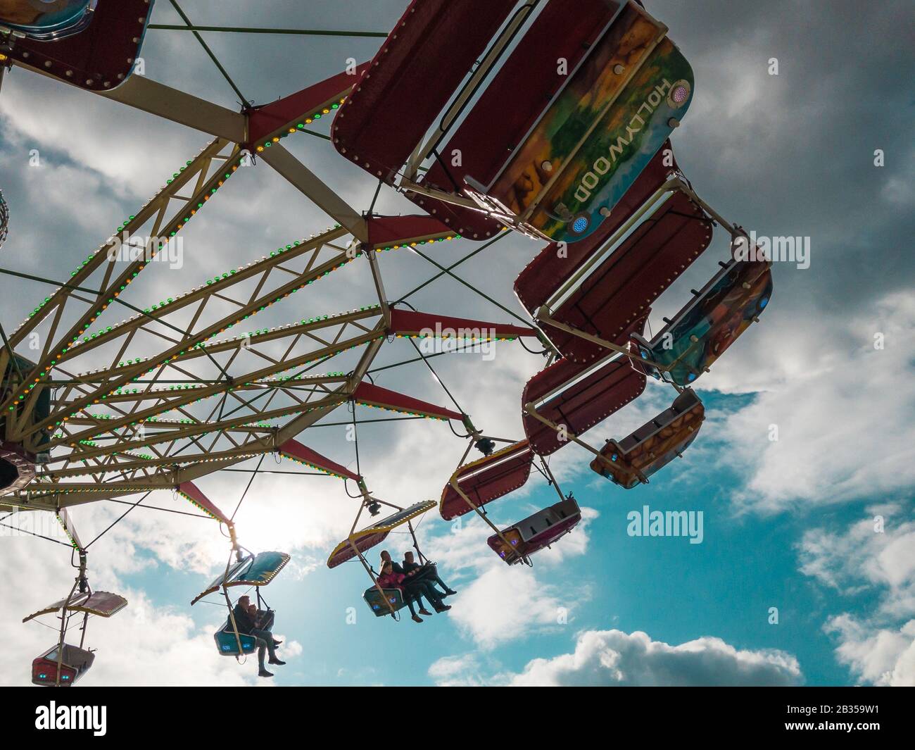 Carousel spinning and a cloudy sky during daytime Stock Photo - Alamy