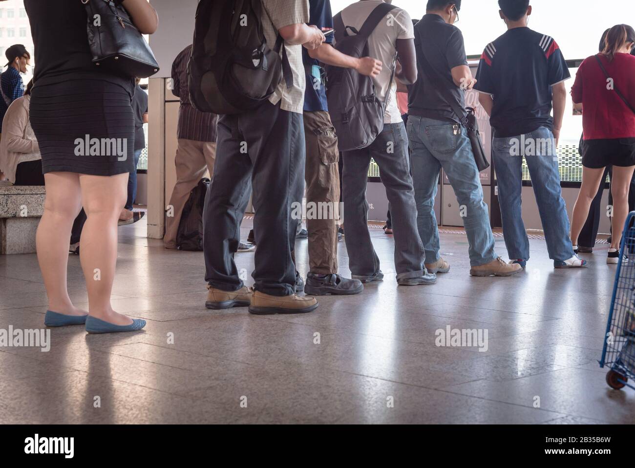Diverse people waiting in line at MRT Mass Rapid Transit train station ...