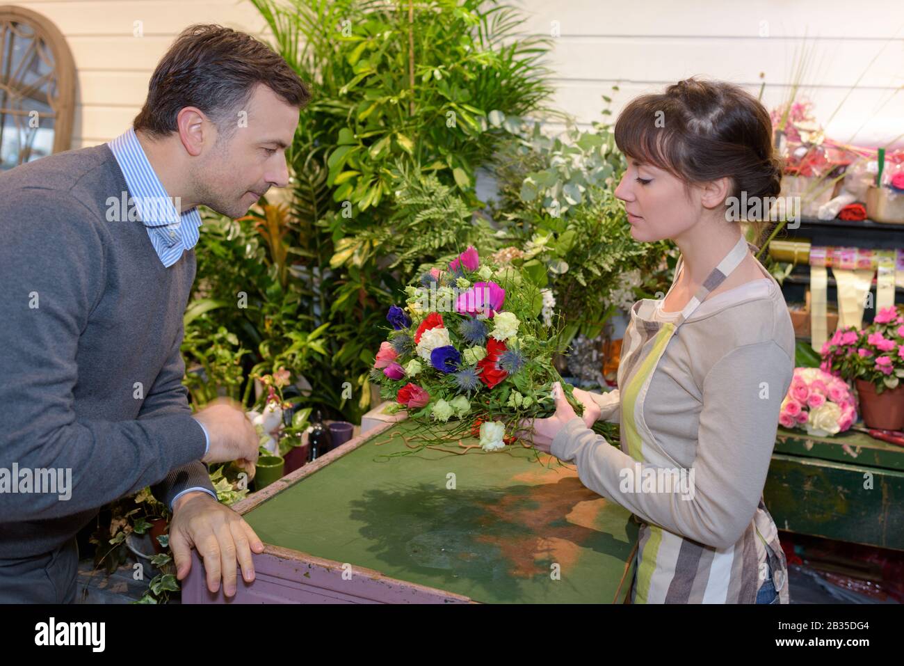 seller helping male client to choose flowers Stock Photo - Alamy