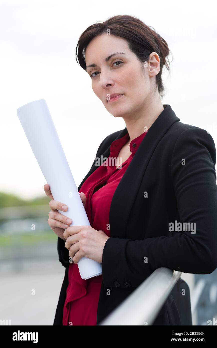 portrait of attractive suited woman holding rolled up paper Stock Photo ...