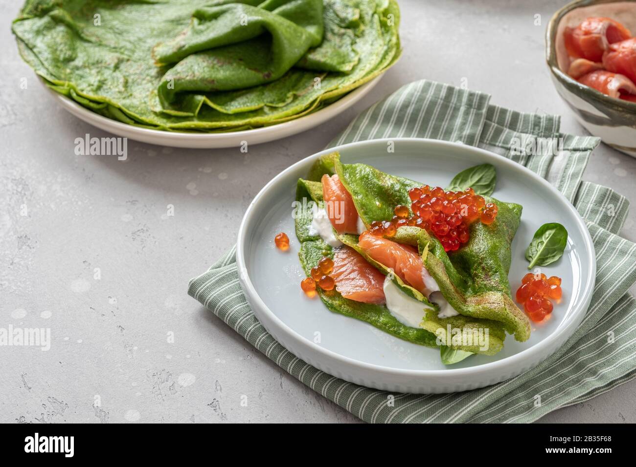 Green spinach crepes with smoked salmon, red caviar and yogurt sauce ...