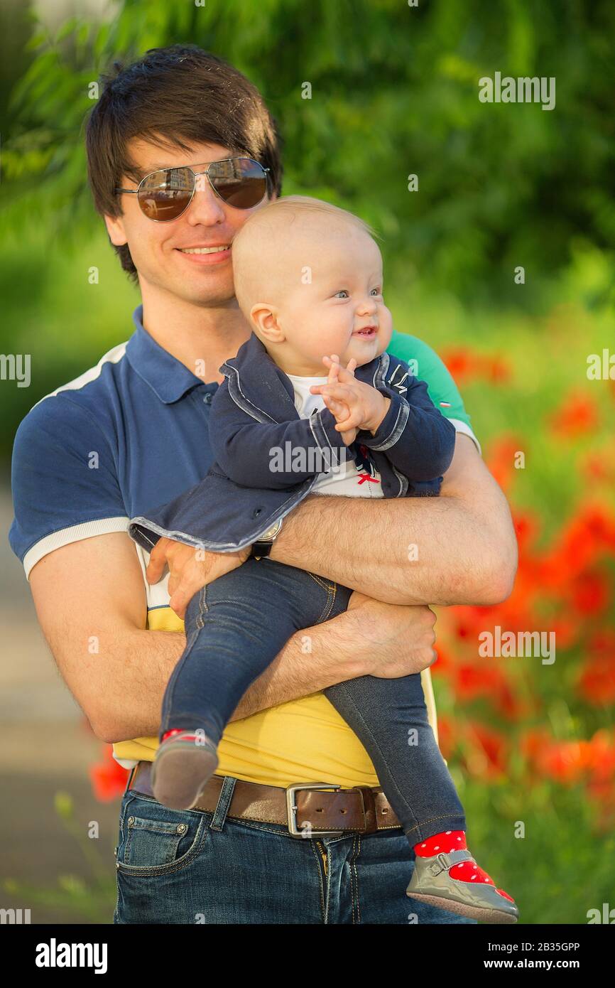 Happy father and child playing together on the poppy meadow. Dad and ...