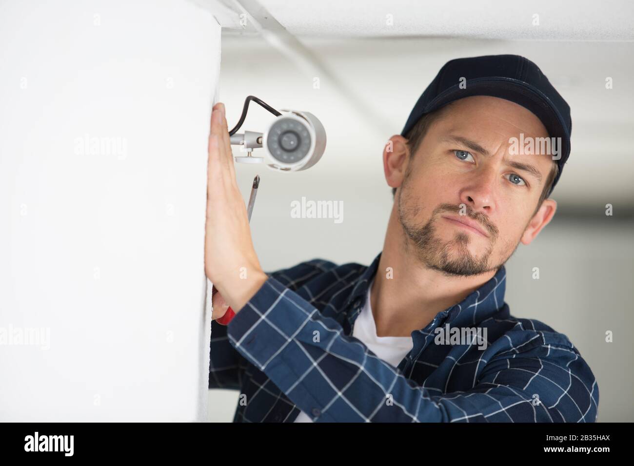 serious thinking man looking up against cctv camera Stock Photo - Alamy