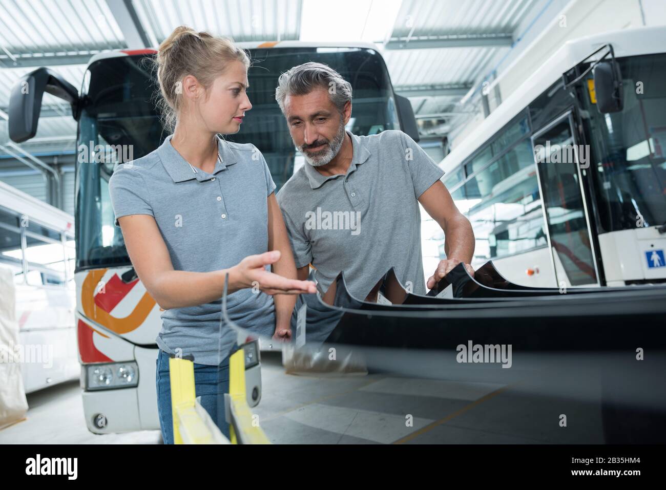 two mechanic of buses talking Stock Photo - Alamy