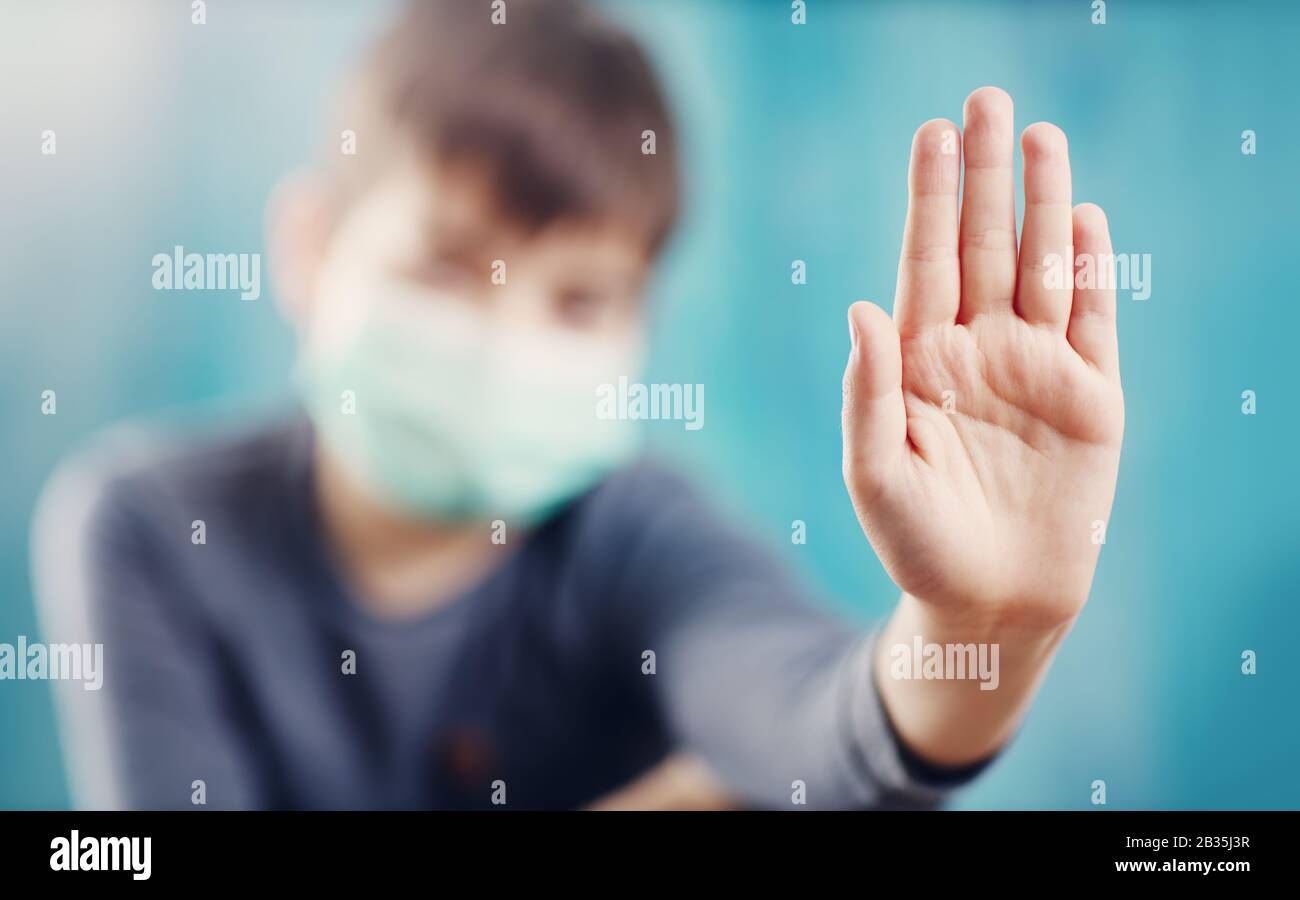 boy in medical face protection mask indoors on blue background. Sick ...