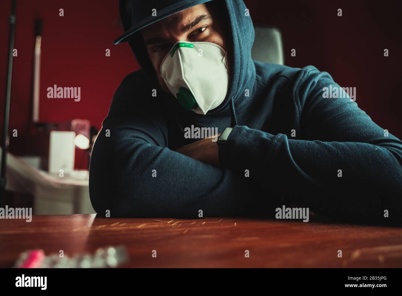 Pills in front of sad man infected with corona virus, respirator mask ...