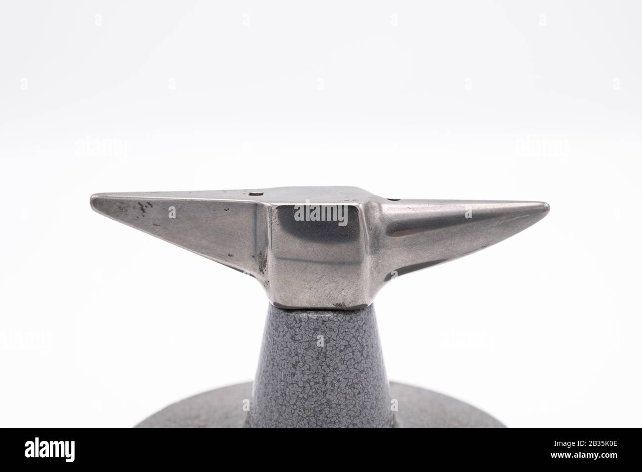Closeup of a small anvil in front of white background Stock Photo - Alamy