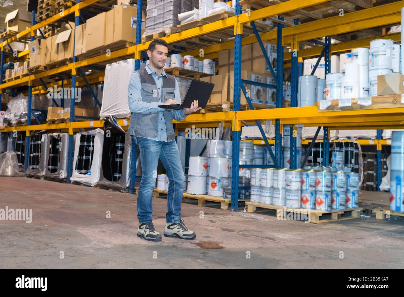 worker checking goods on belt in distribution warehouse Stock Photo - Alamy