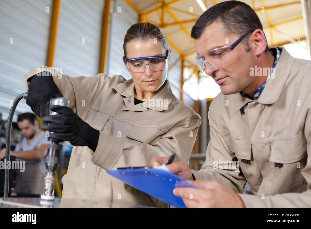 engineering factory with staff in background Stock Photo - Alamy
