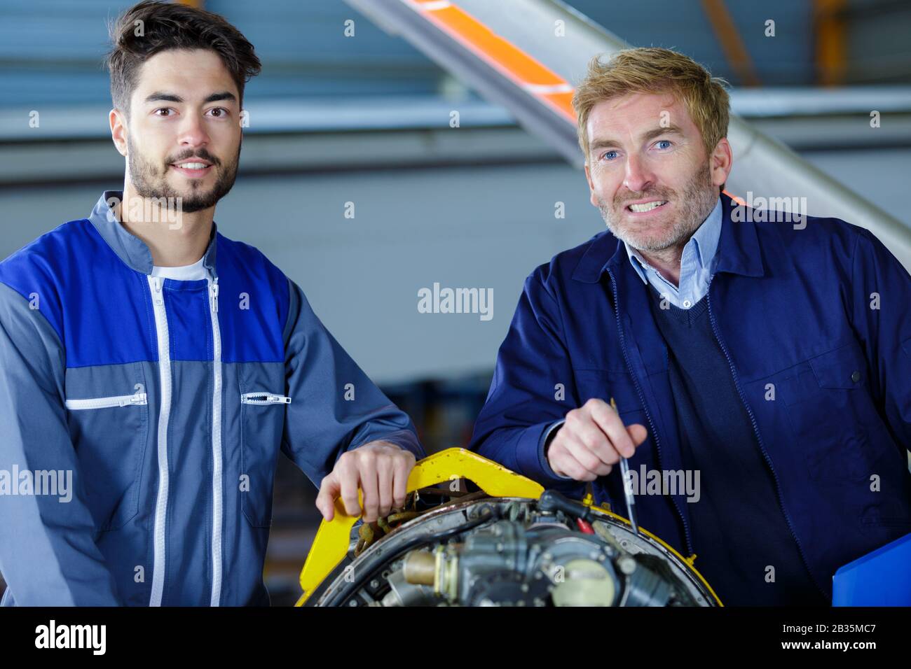 airplane service crew repairing plane in hangar Stock Photo - Alamy