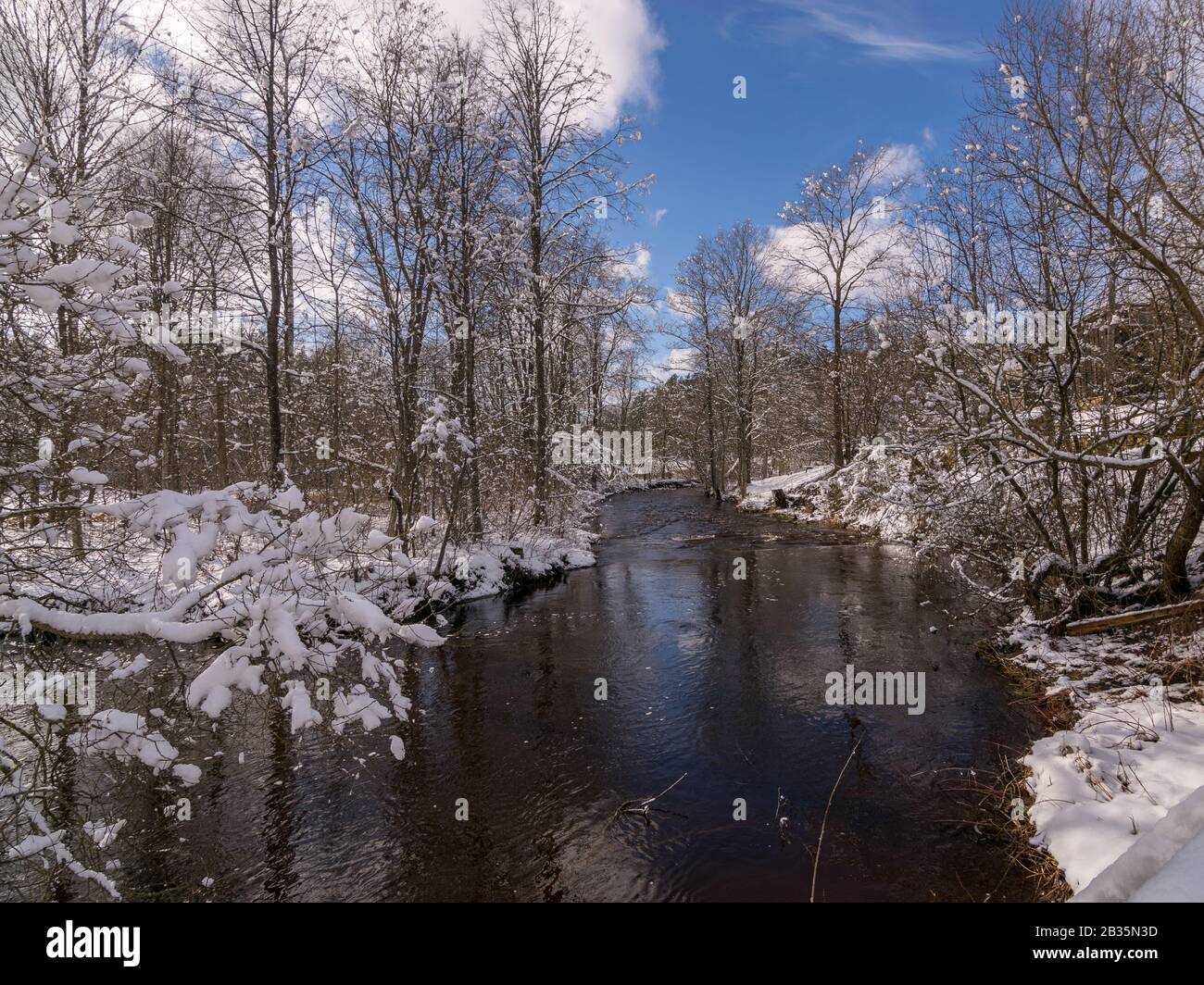 winter landscape with wild fast flowing river, snow covered land, lots ...