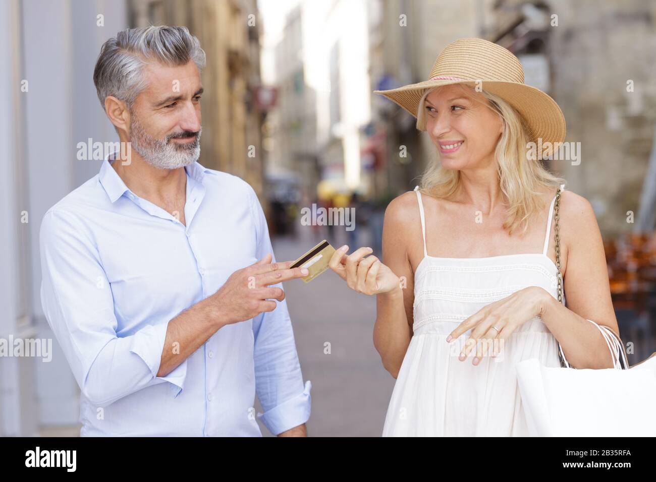 man give credit card to girlfriend on street in summer Stock Photo - Alamy