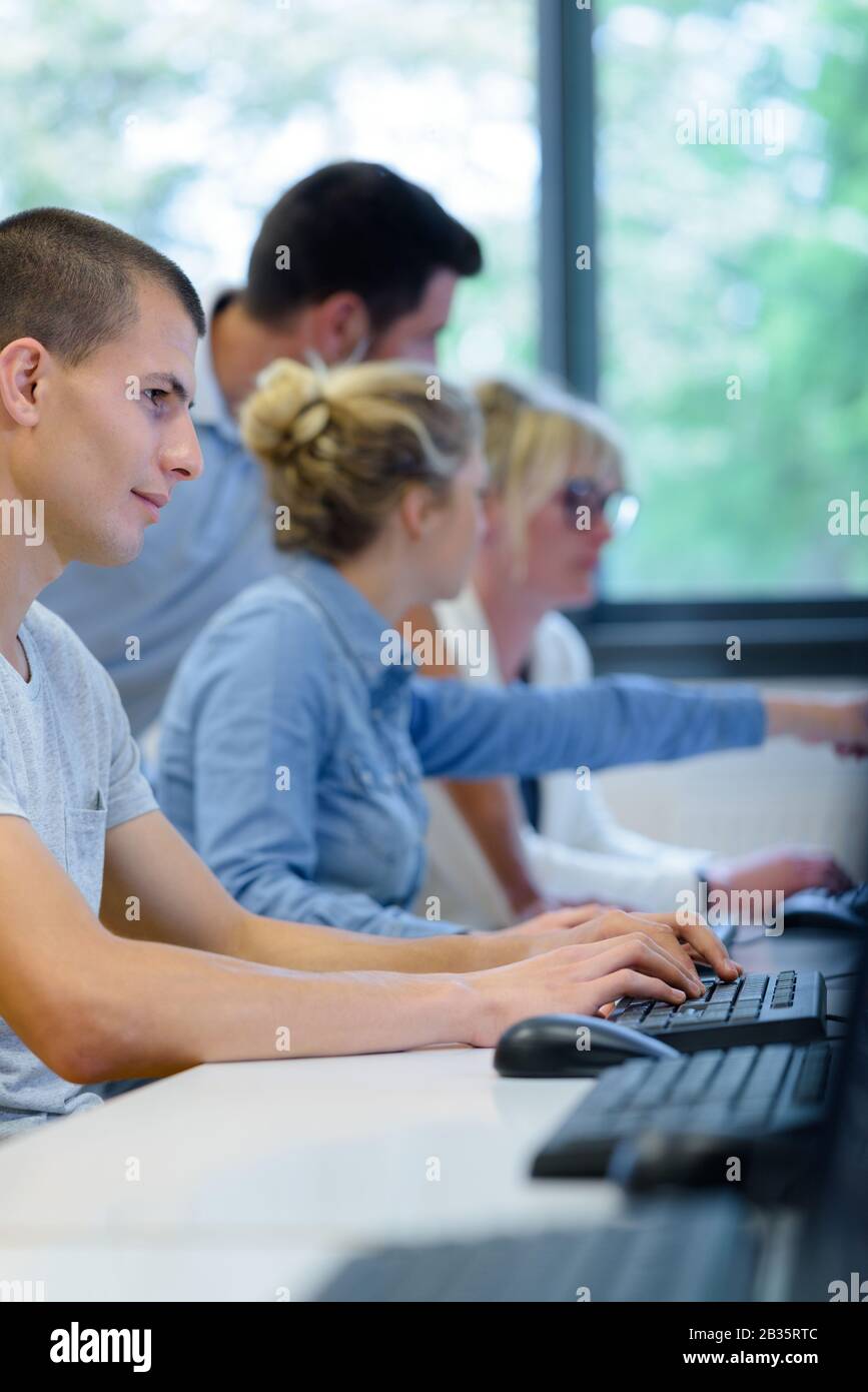 side view of student smiling while using a laptop Stock Photo - Alamy