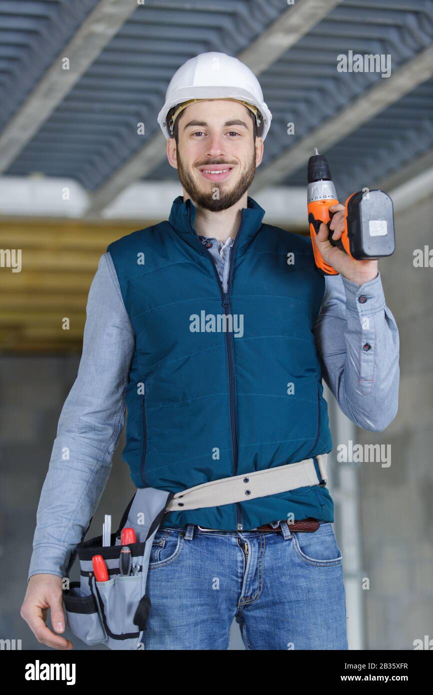 builder keeping drill indoors Stock Photo - Alamy