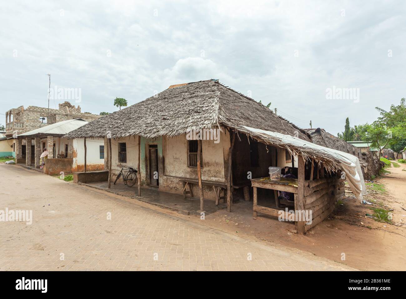 Rural homes in a village in East Kenya, next to a road, with trees ...