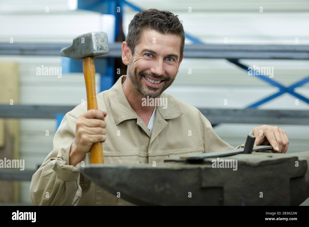 happy man is hammering an iron hook with a hammer Stock Photo - Alamy
