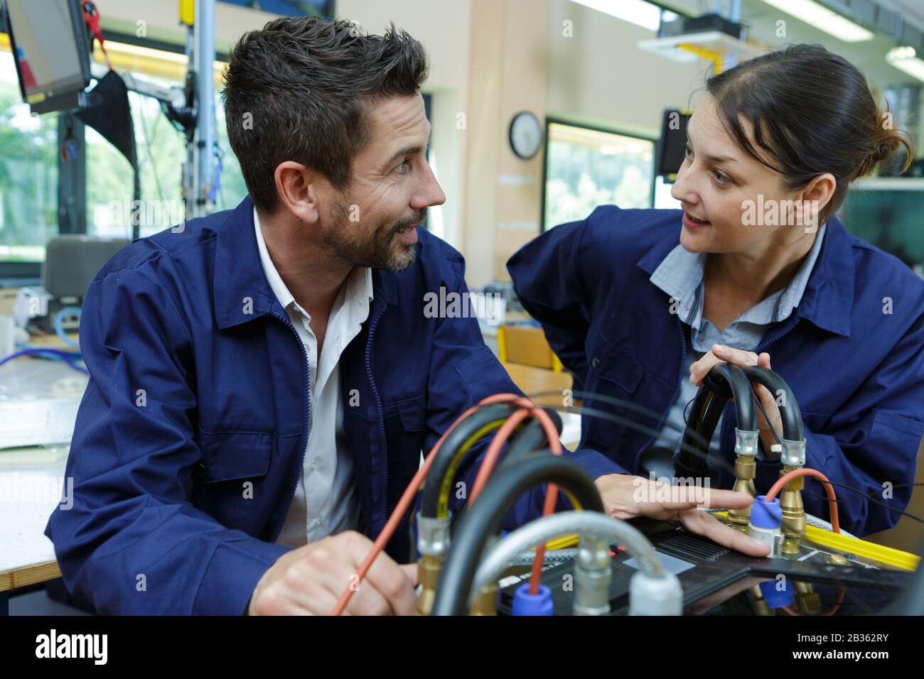 a portrait of two engineers working with cables Stock Photo - Alamy