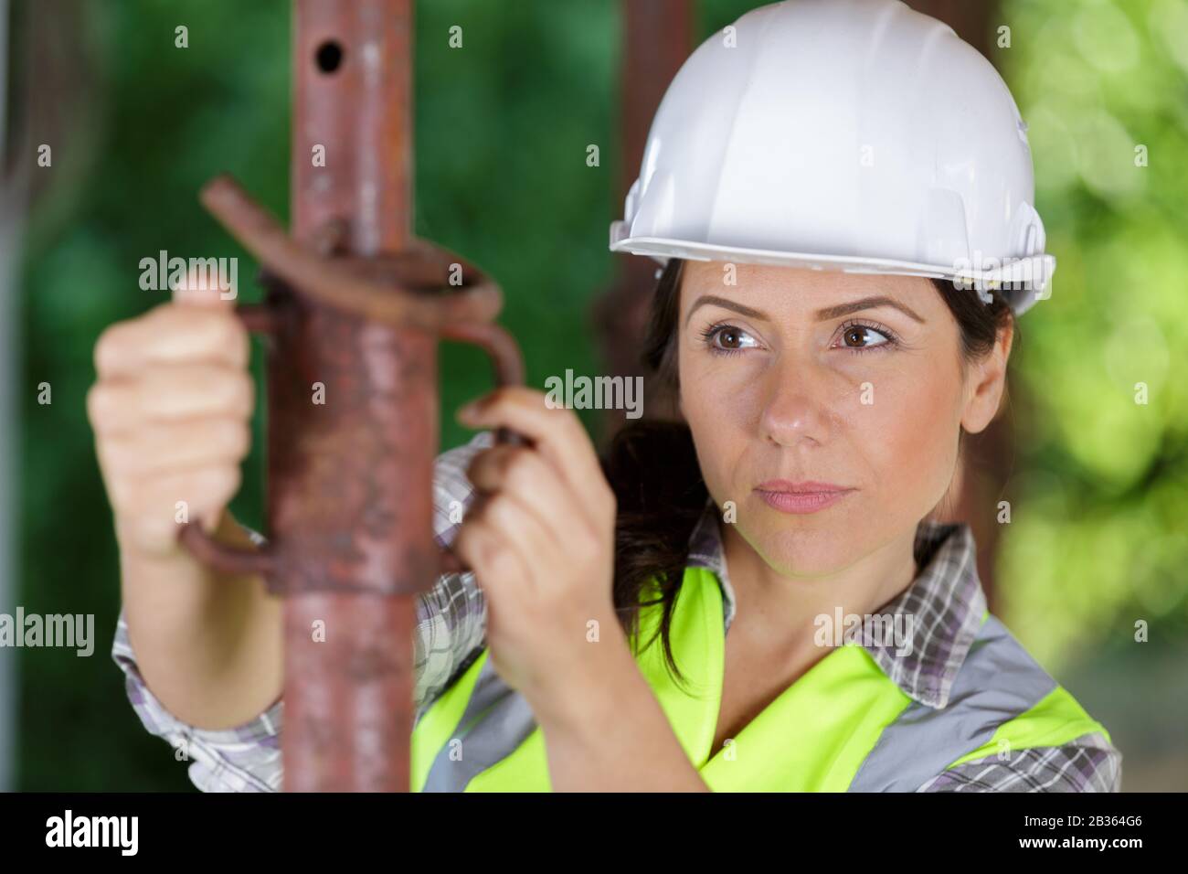 female builder adjusting level of acrow prop Stock Photo - Alamy