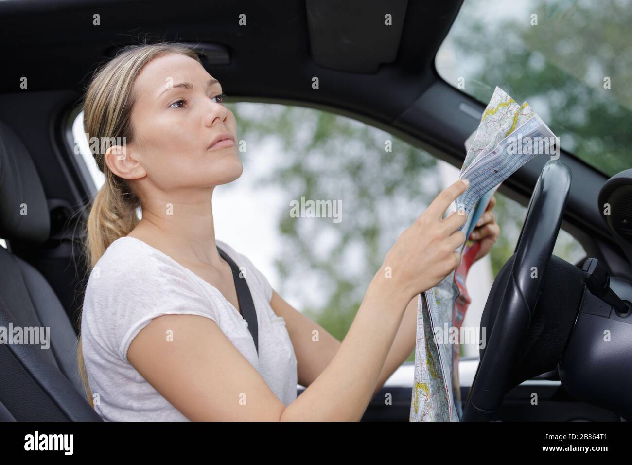 woman looking at a map in the car Stock Photo - Alamy