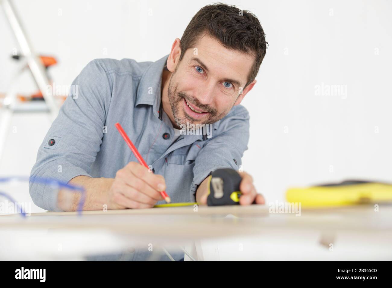 manual worker using a measuring tape and pencil Stock Photo - Alamy