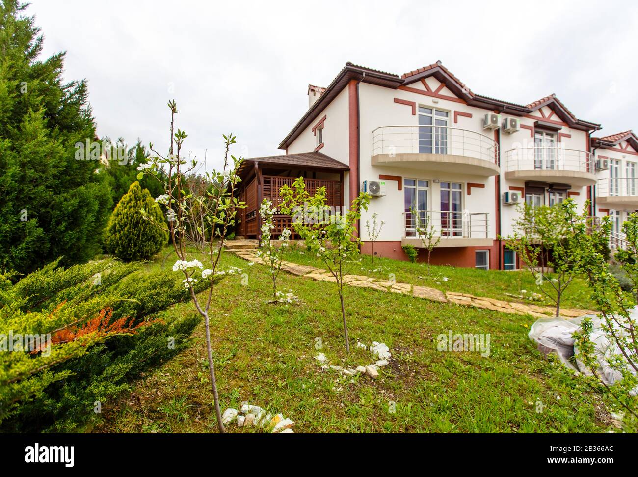 The courtyard of the cottage is covered with green grass. Young, newly ...