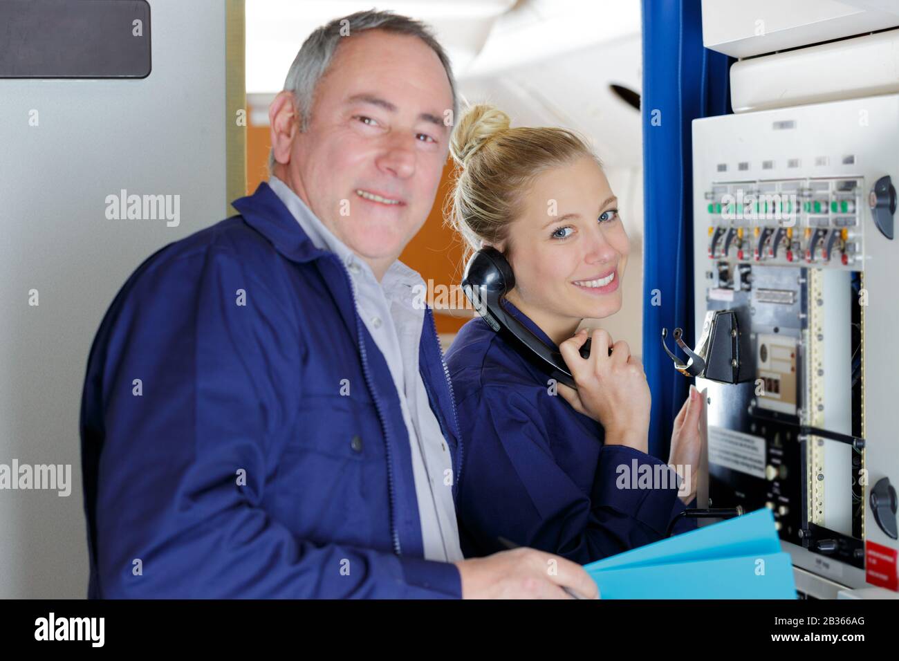 portrait of technicians stood by aircraft in-flight communication ...