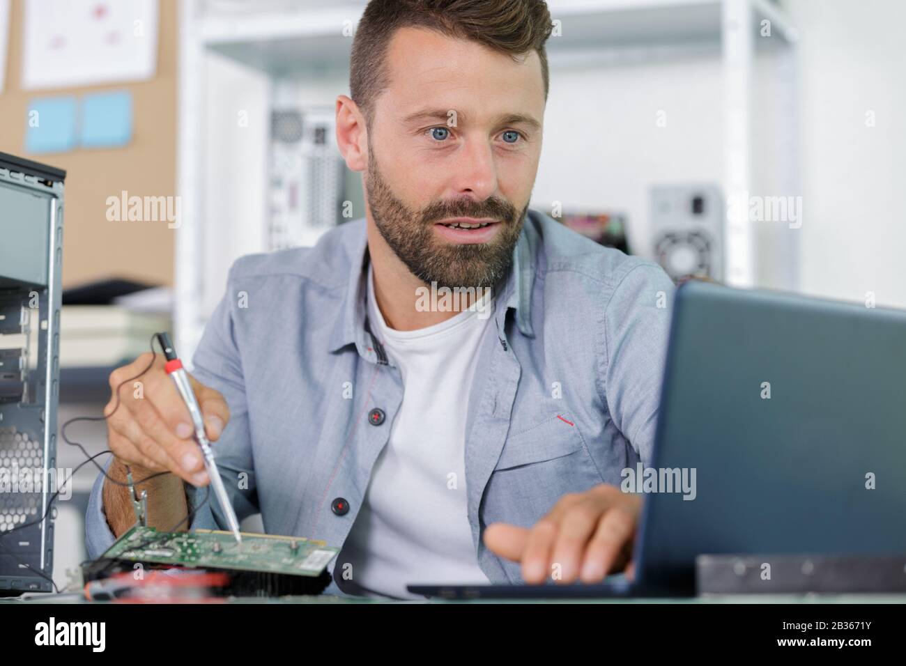 technician looking at laptop while repairing a computer Stock Photo - Alamy