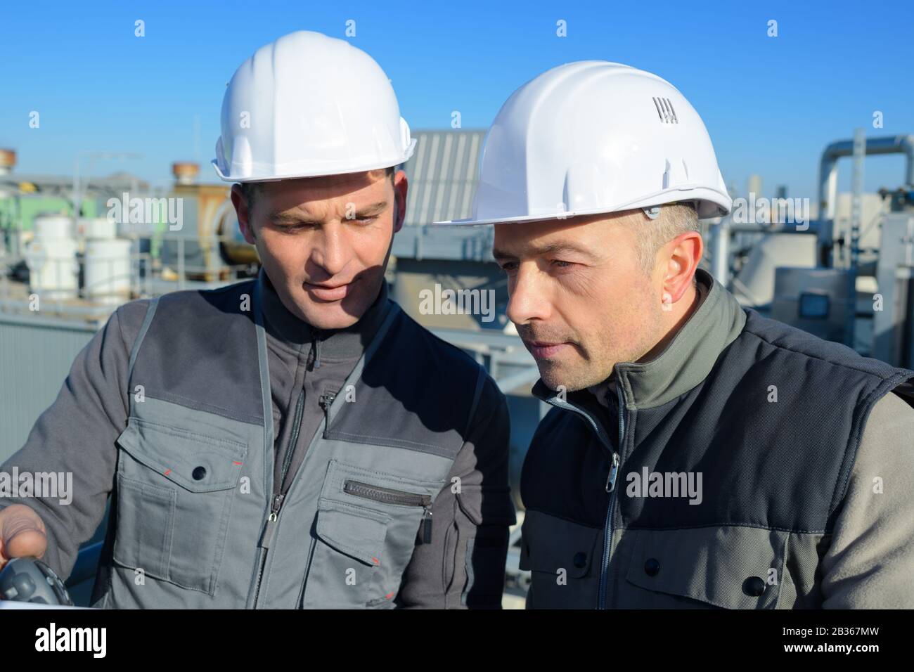 two factory workers discussion and pointing for inspection Stock Photo ...
