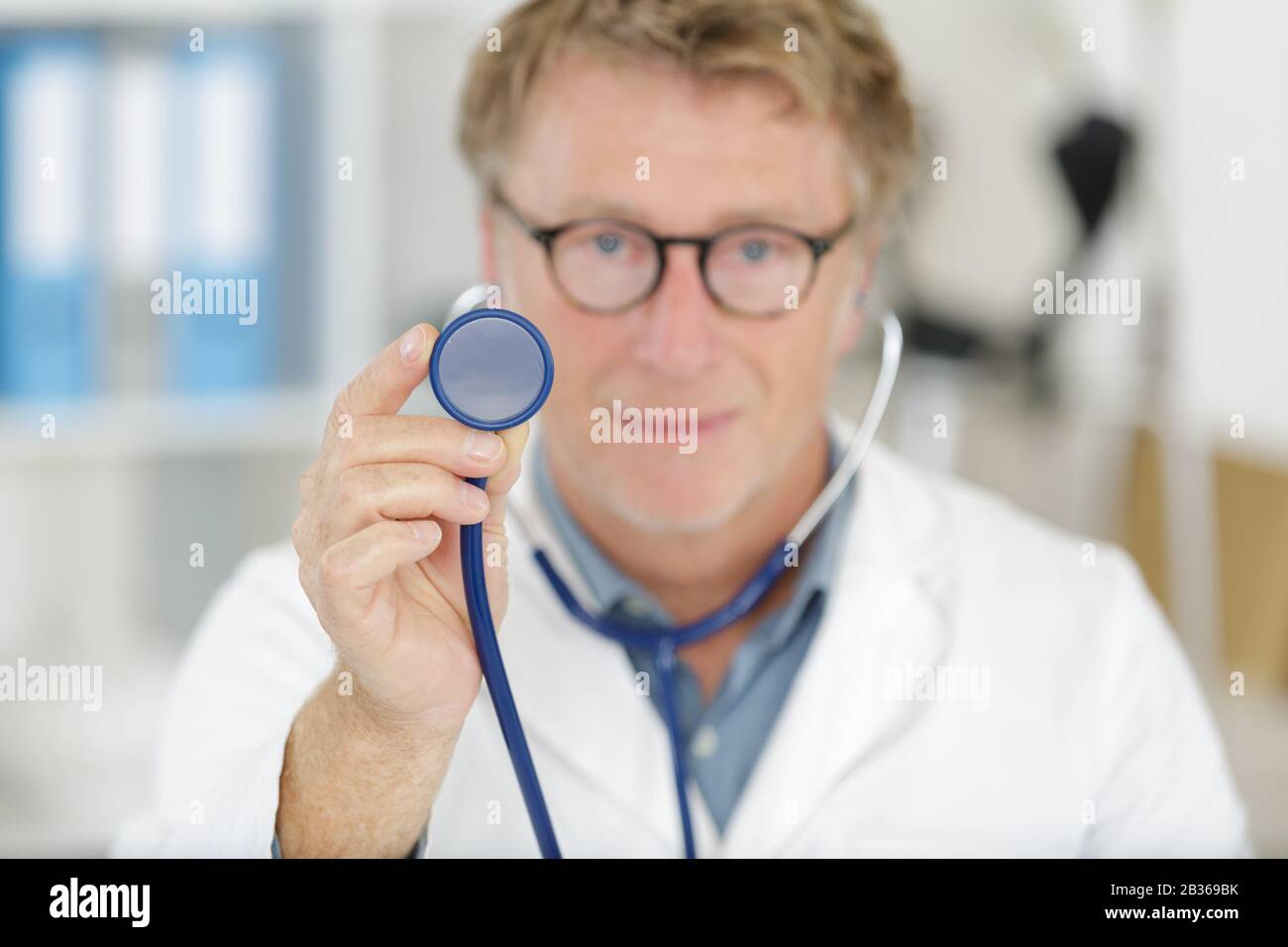 a mature doctor using stethoscope Stock Photo - Alamy